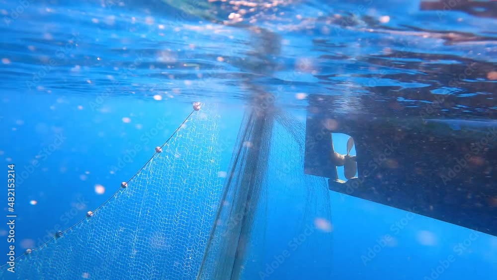 4K.Fishing net hanging from the boat under the sea.Underwater fishing ...