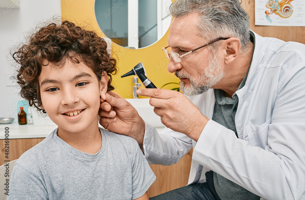 Otoscopy and hearing check-up for boy at audiology office. Pediatrician ...