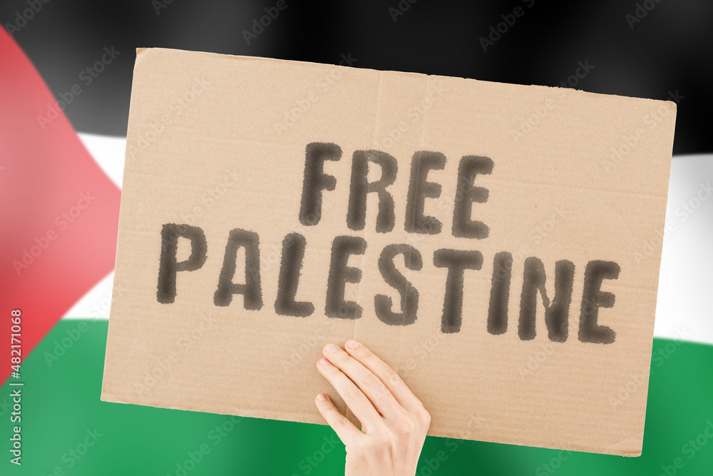 The phrase " Free Palestine " on a banner in men's hand with blurred ...