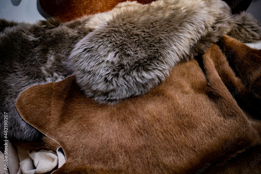 natural animal skins stacked in a pile for sale. cow and sheep skin ...