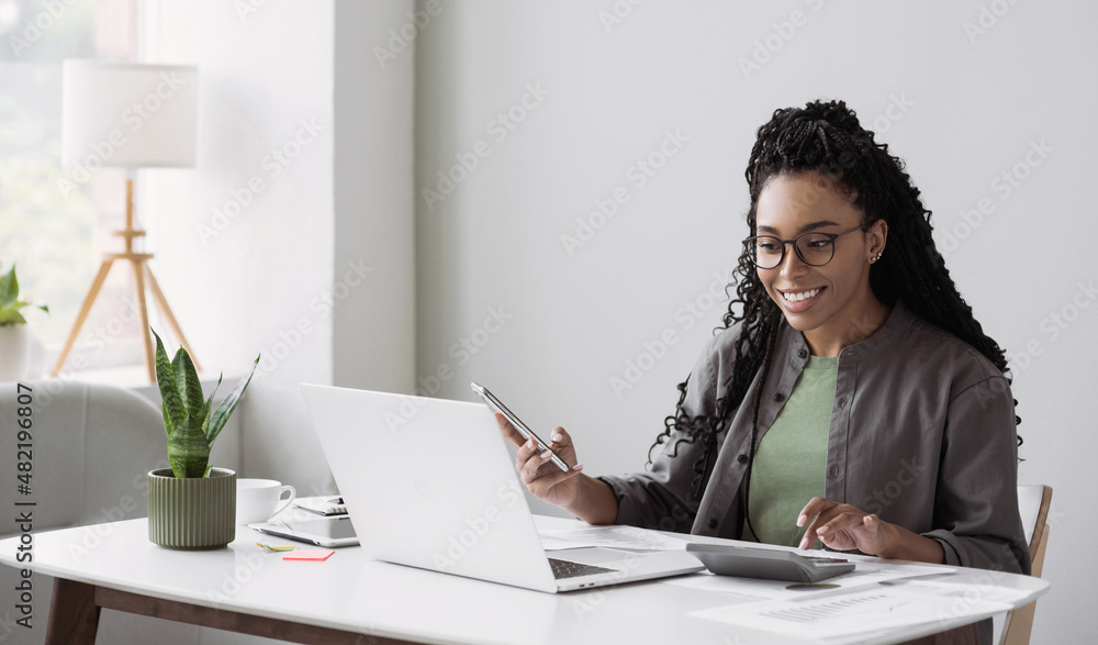 Woman accountant using calculator and laptop computer in office ...
