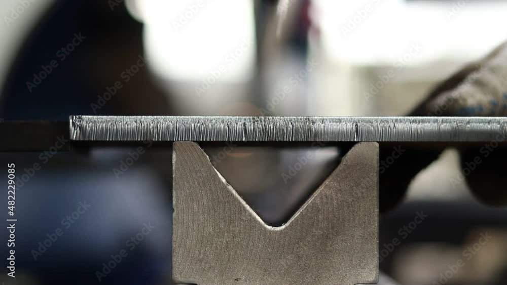 Work in heavy industry. A bending machine operator bends a thick, rusty ...