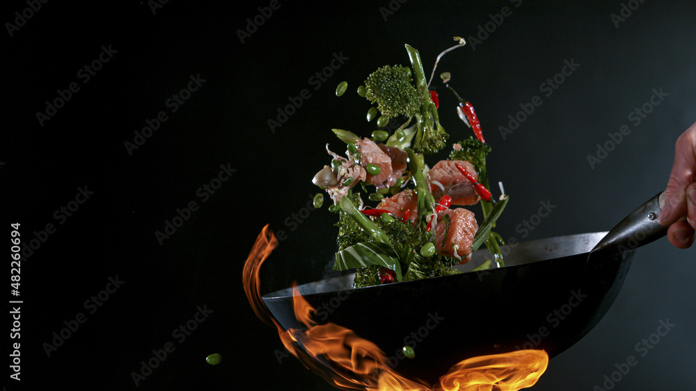 Freeze Motion of Wok Pan with Flying Ingredients in the Air and Fire ...