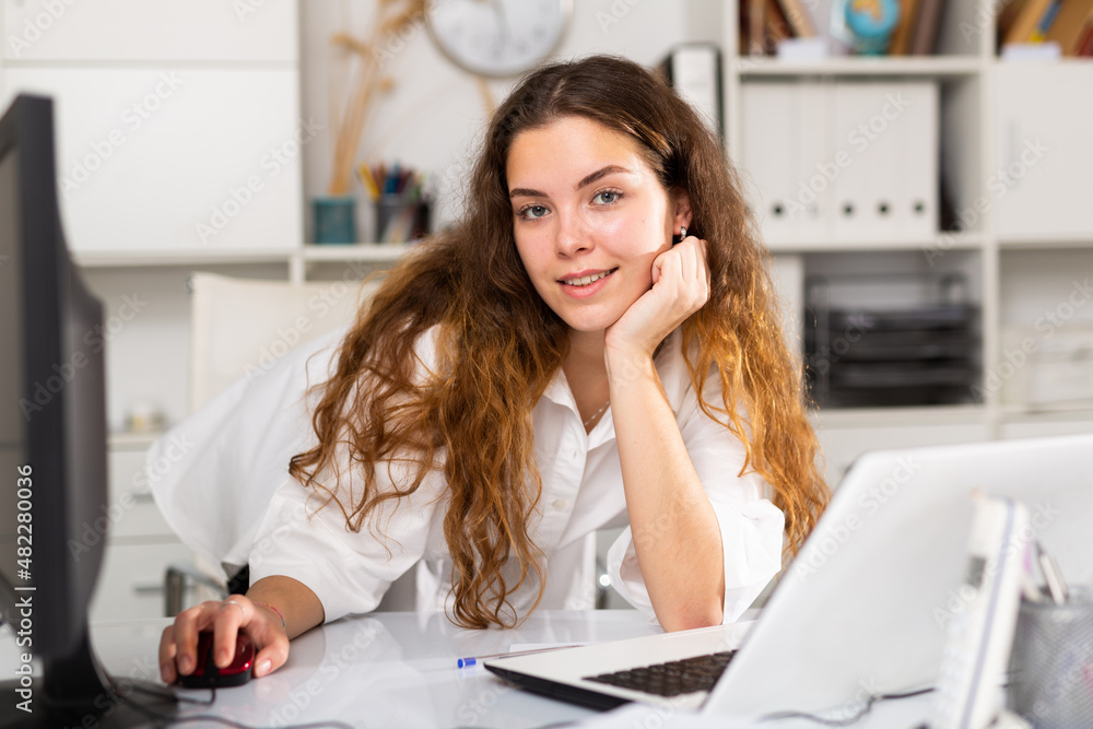 European girl journalist office employee working alone on laptop and ...