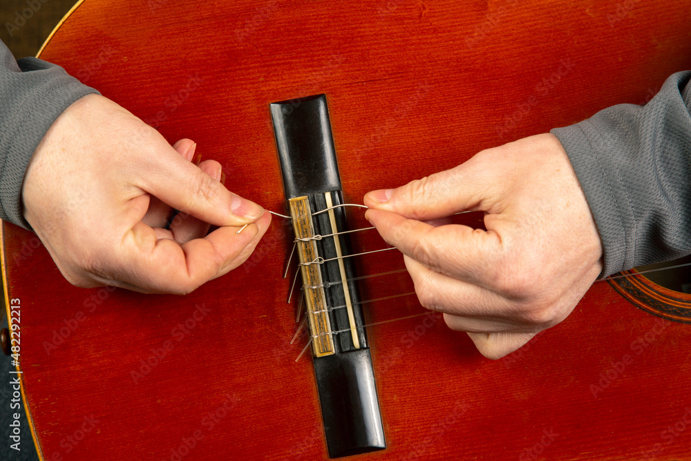 replacement and insertion of nylon strings in a classical guitar ...