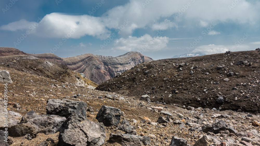 The top of an active volcano. Rocky soil is visible, the layered ...