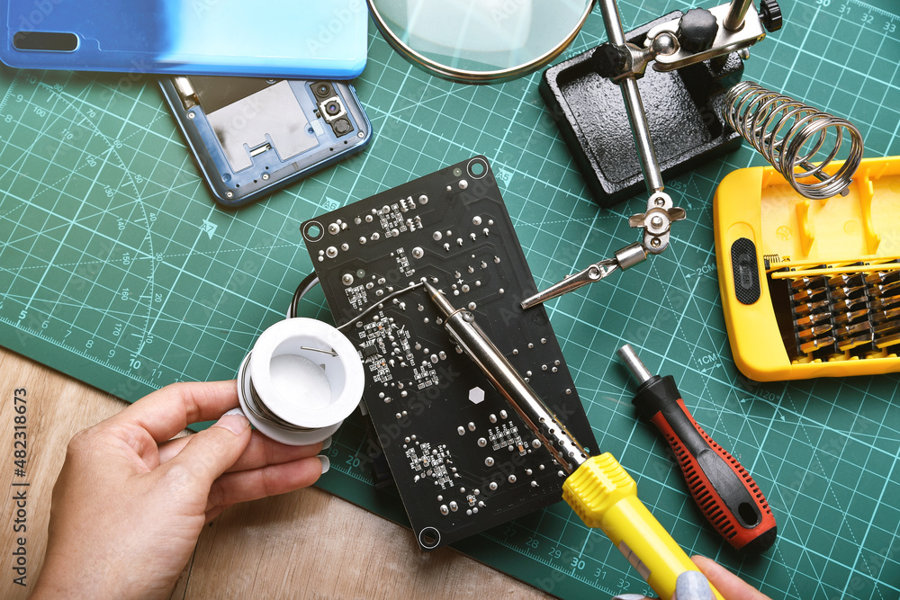Electronics repair service, Technician fixing electronic circuit board ...