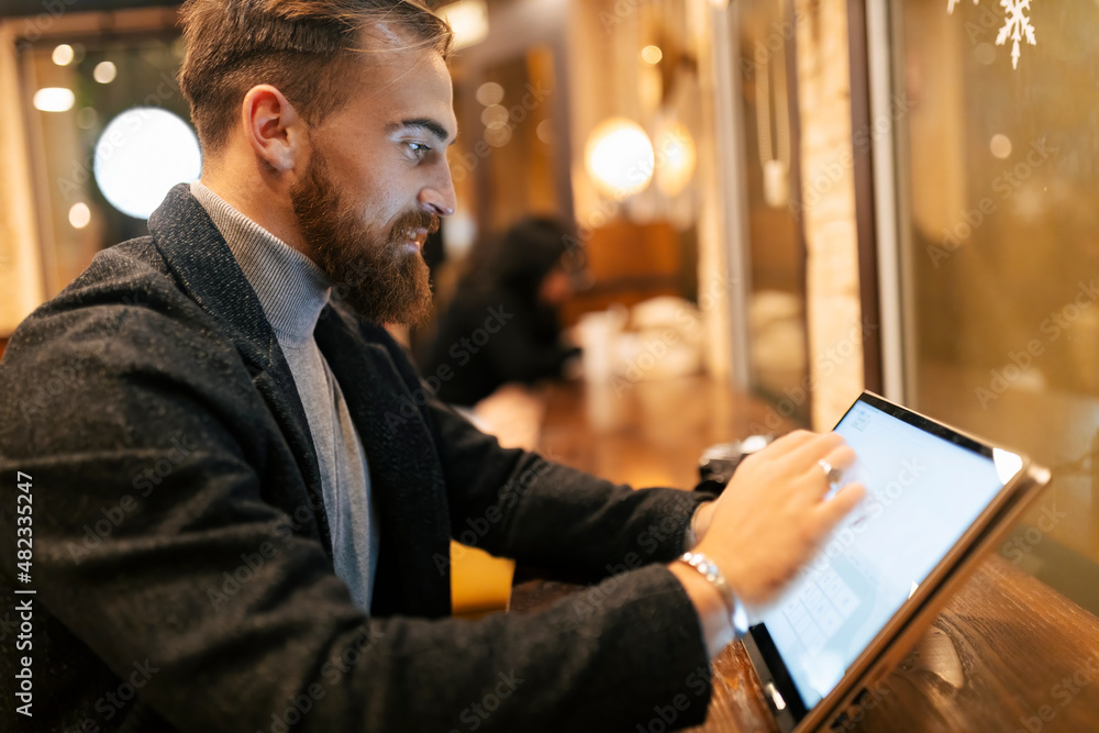 Freelancer using touch screen laptop at restaurant Stock Photo | Adobe ...