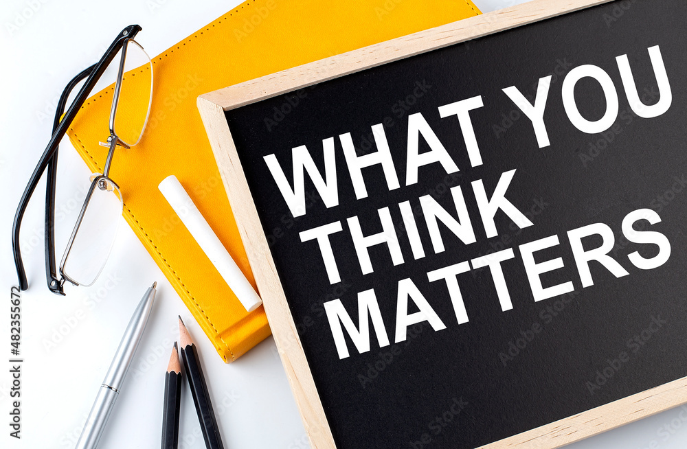 WHAT YOU THINK MATTERS text on the blackboard with notepad , pen ...