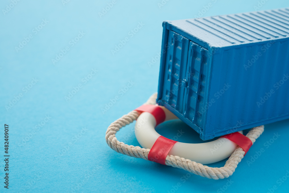 Blue container on lifebuoy blue background with copy space. Marine ...
