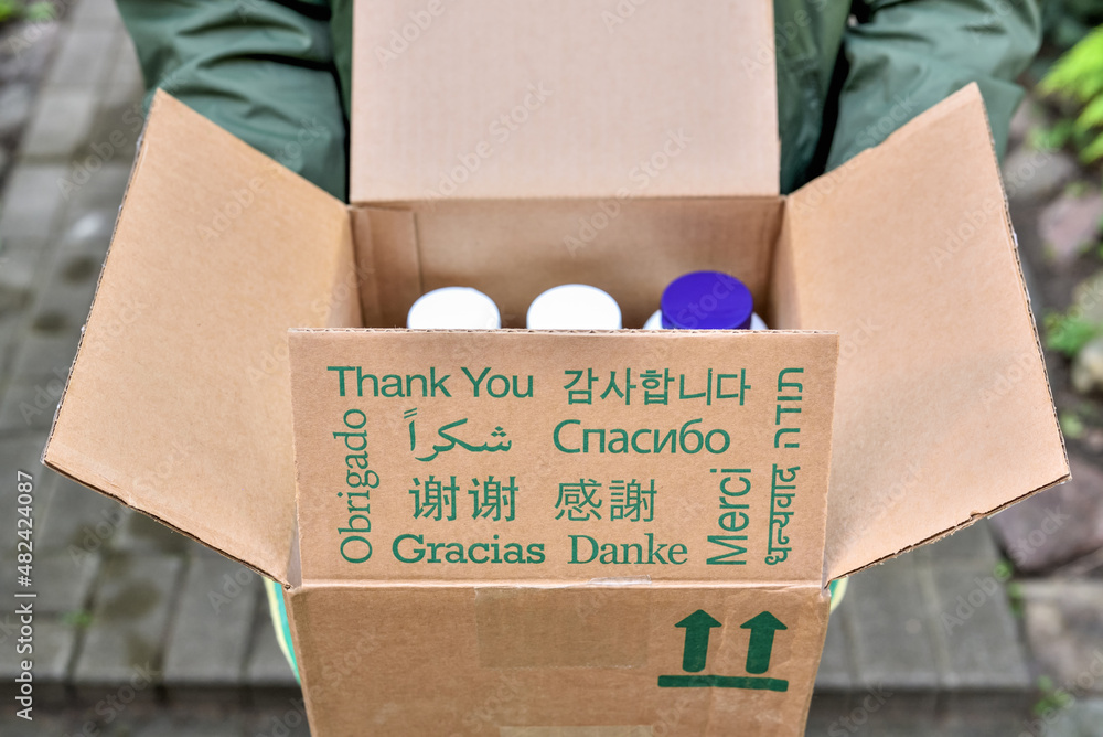 Inscription Thank you in different languages on the open cardboard box ...
