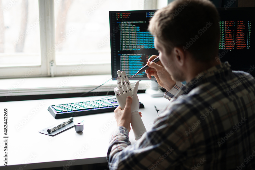 male engineer working on the development of robotic arm or hand, new ...