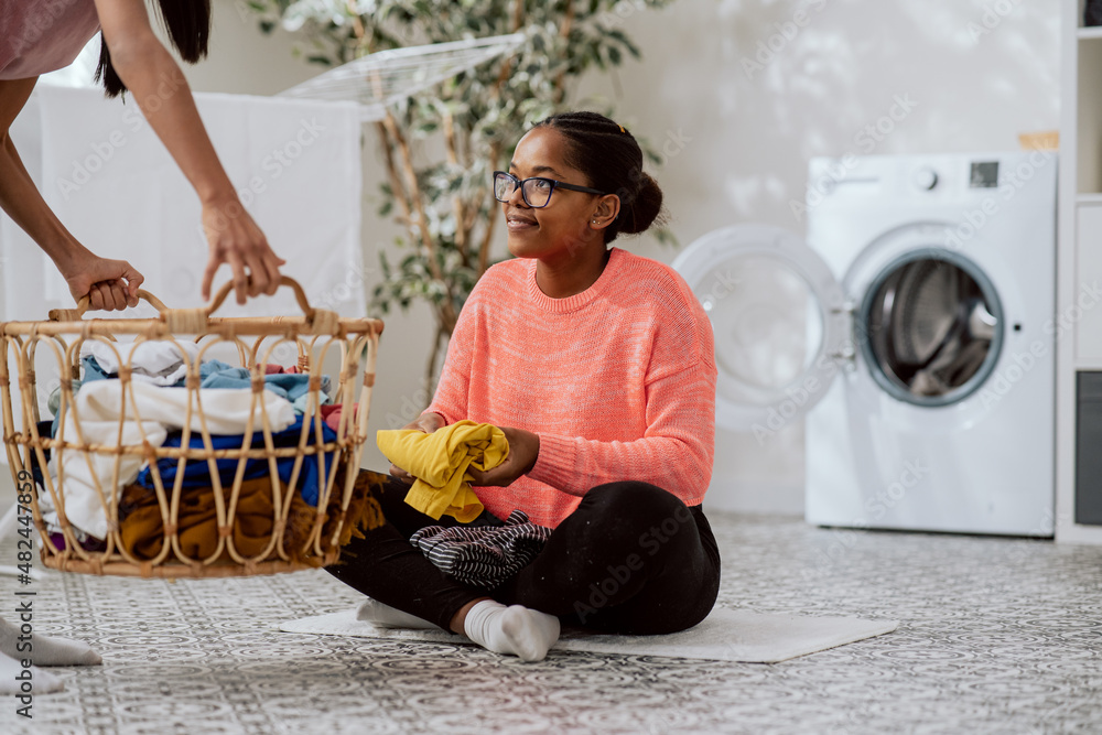 Teenager brings wicker basket with dirty clothes to mother for washing ...