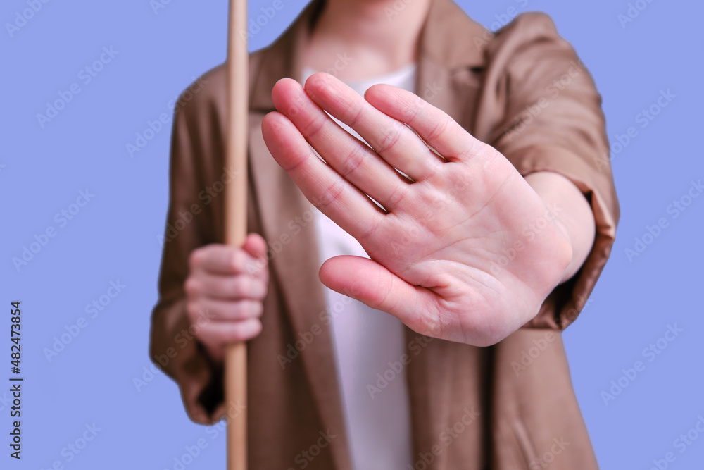 Woman teacher with hand gesture refusal on studio blue background, copy ...