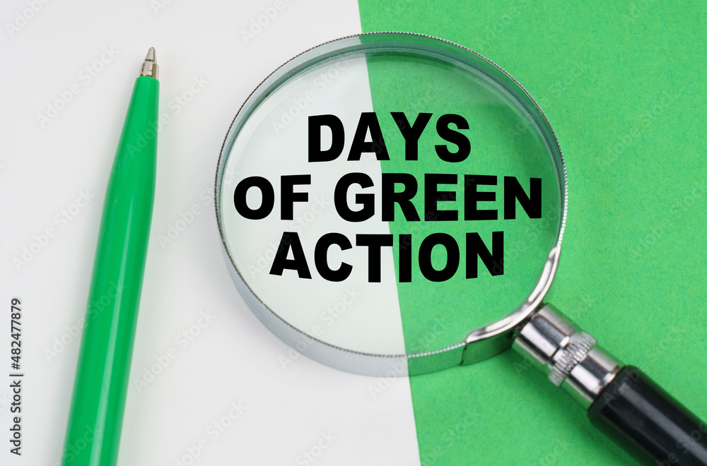 On a white-green background lies a pen and a magnifying glass, inside ...