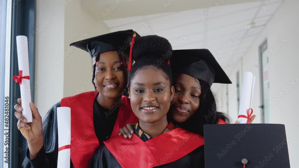 African american university woman graduates stand in front of the ...