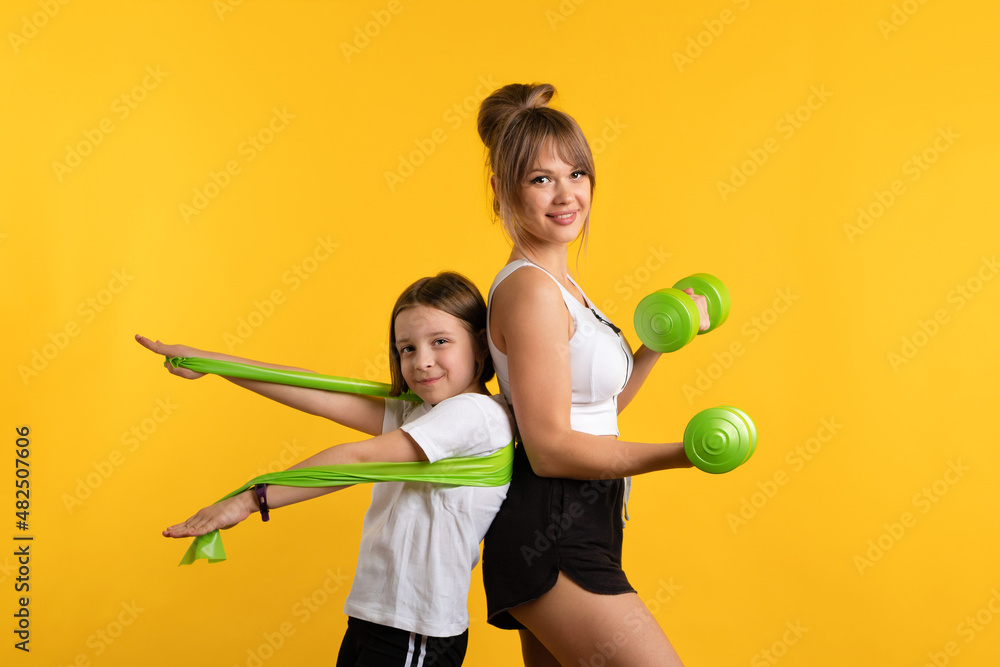 Healthy fit mom and daughter wearing sport wear in studio using ...