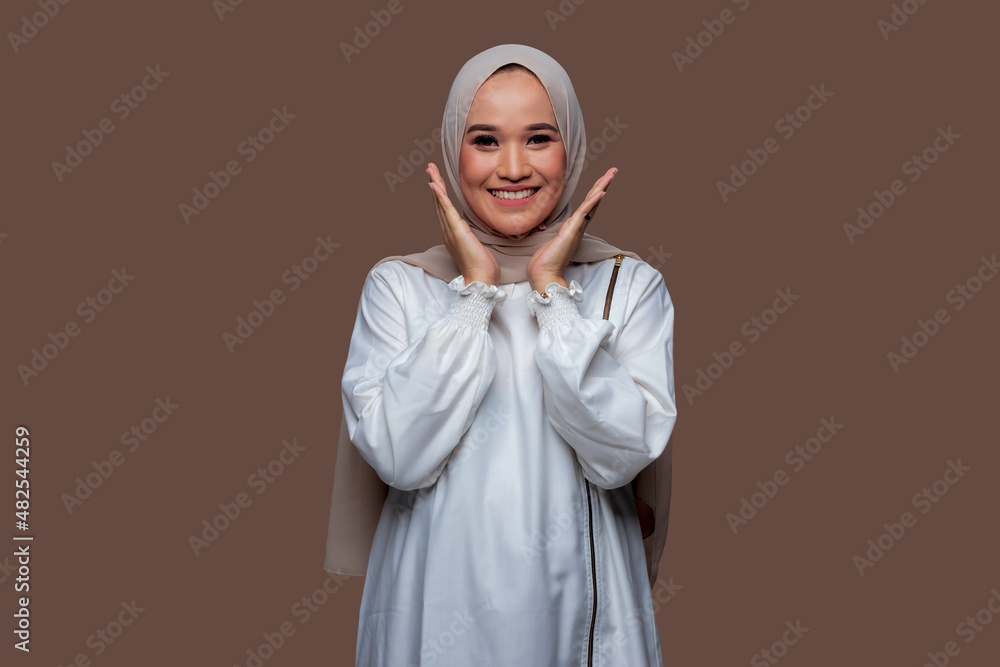 Beautiful woman with happy smile while raising her hands to her cheeks ...