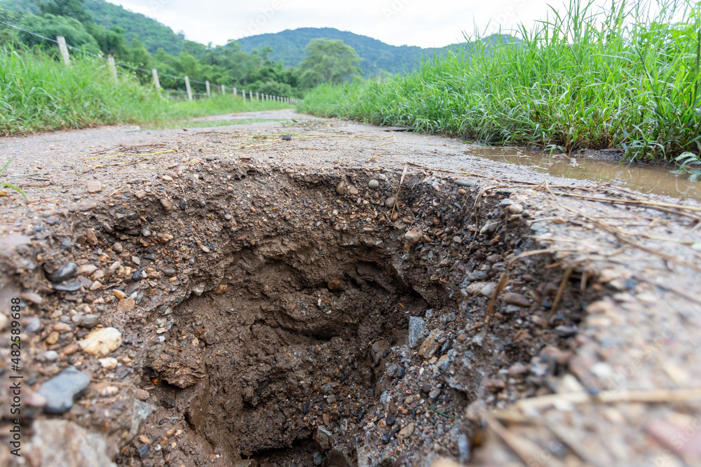 big hole on the ground country road due to broken pipes under the road ...