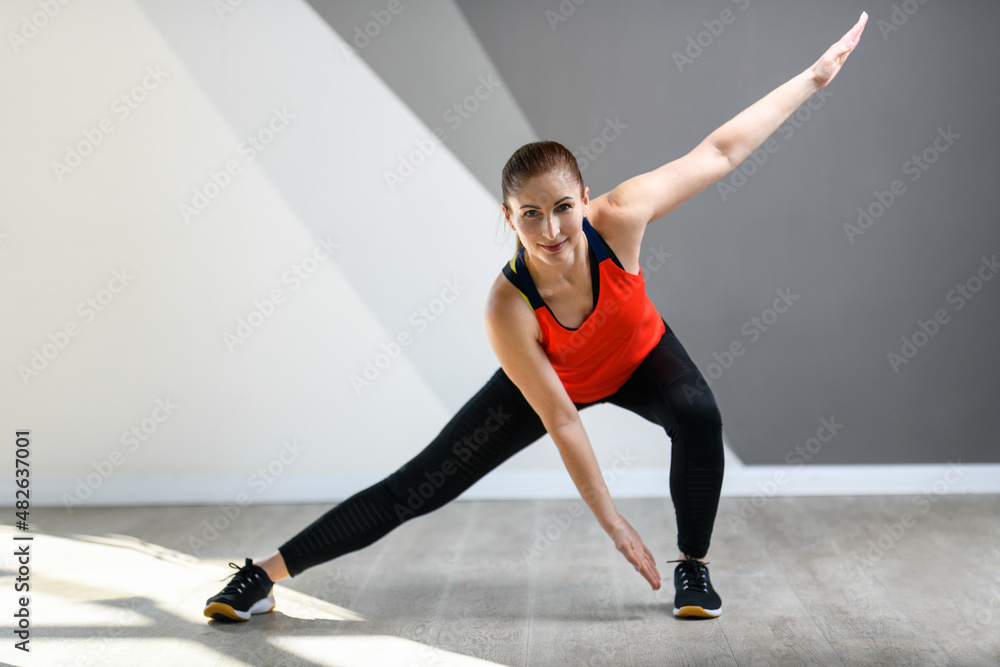 Girl doing exercises in the gym: sit-ups. Middle aged sportswoman ...