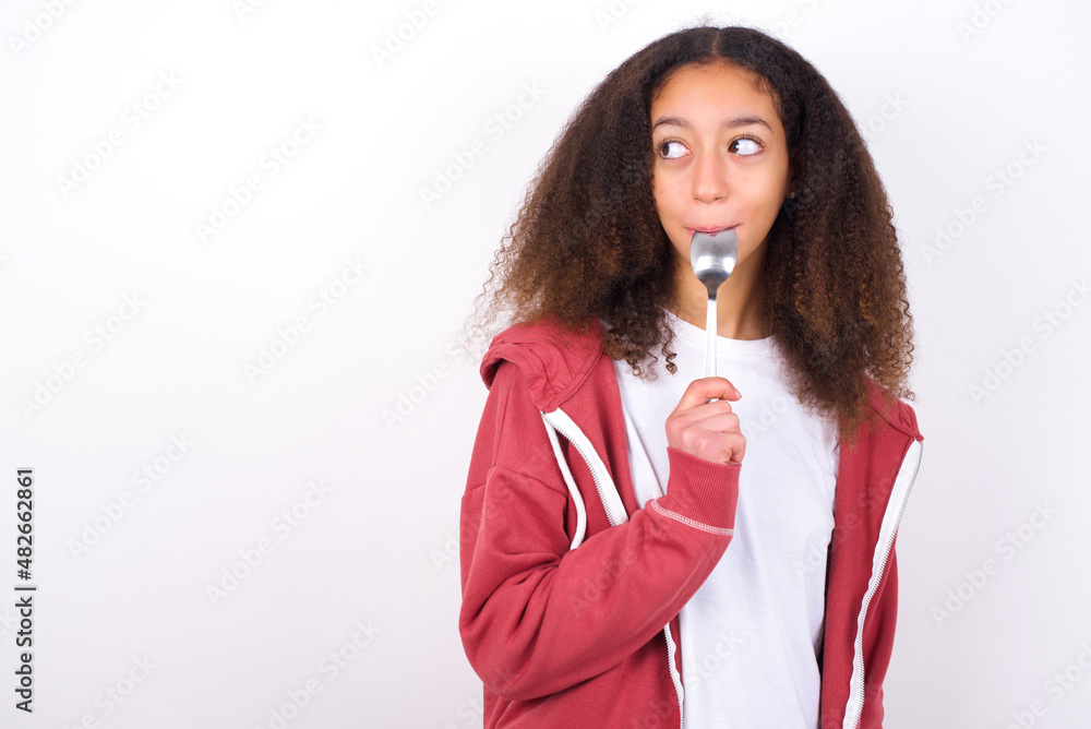Very hungry teenager girl wearing pink jacket standing against wite ...