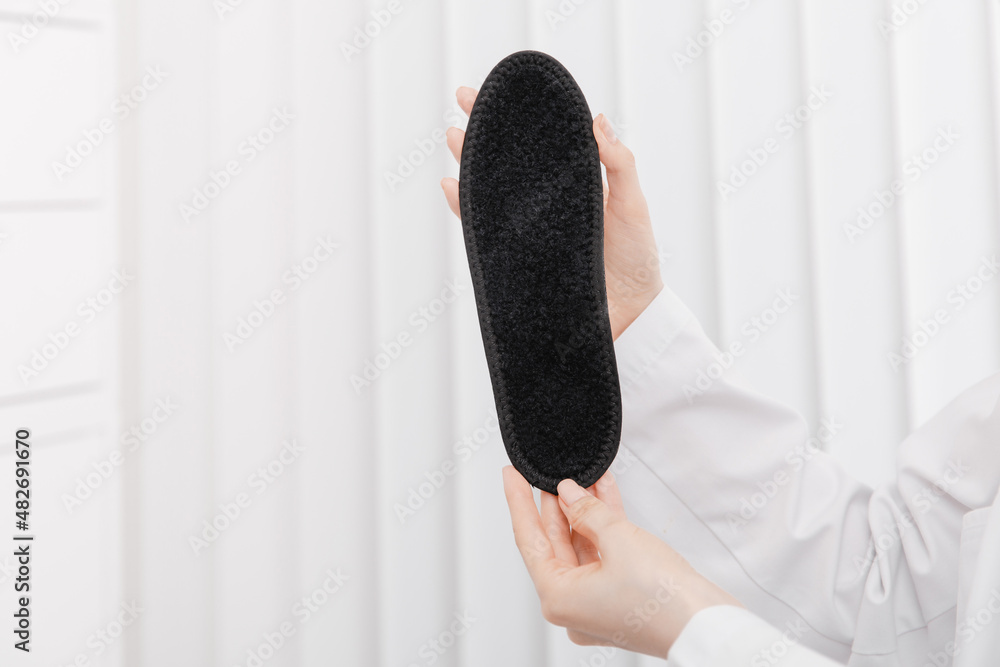 Doctor holding orthopedic insoles in his hands. Orthopedist tests the ...