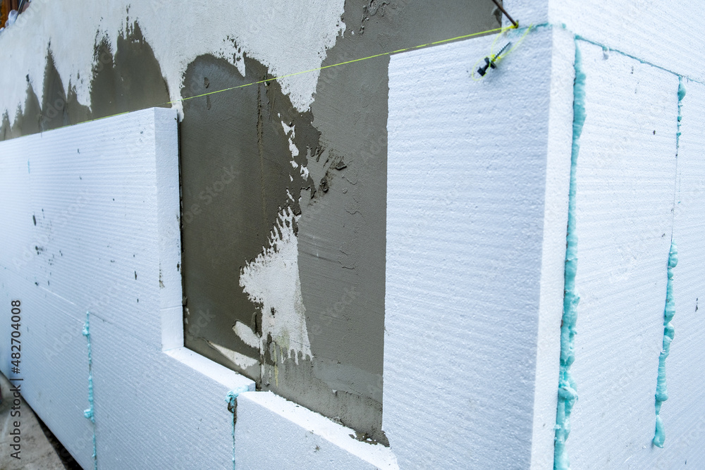 Installation of styrofoam insulation sheets on house facade wall for ...