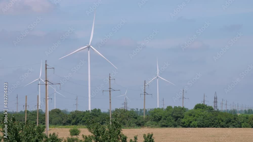 Wind energy station at farm. Powerful wind turbines operate near high ...