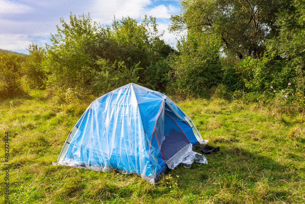 blue tent of a tourist in nature is covered with oilcloth or ...