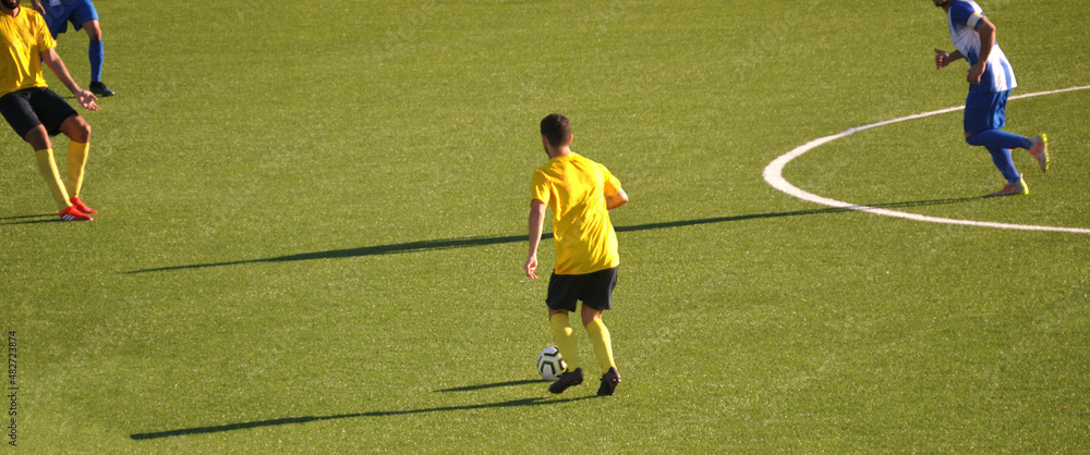 Momento de um jogo de futebol com disputa de bola na zona do meio campo ...