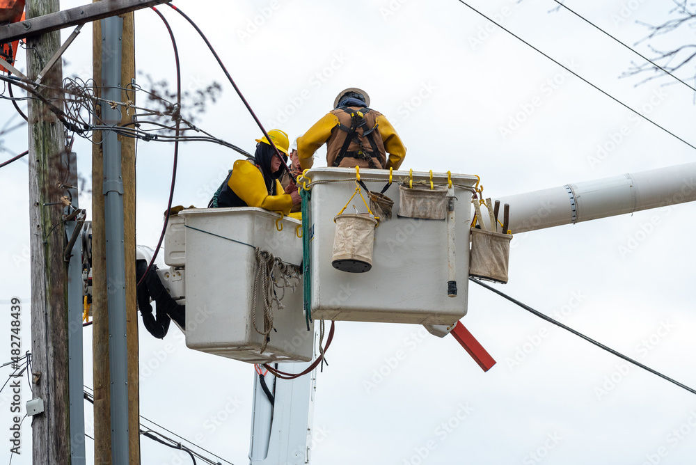 Electricians are climbing on electric poles to install and repair power ...