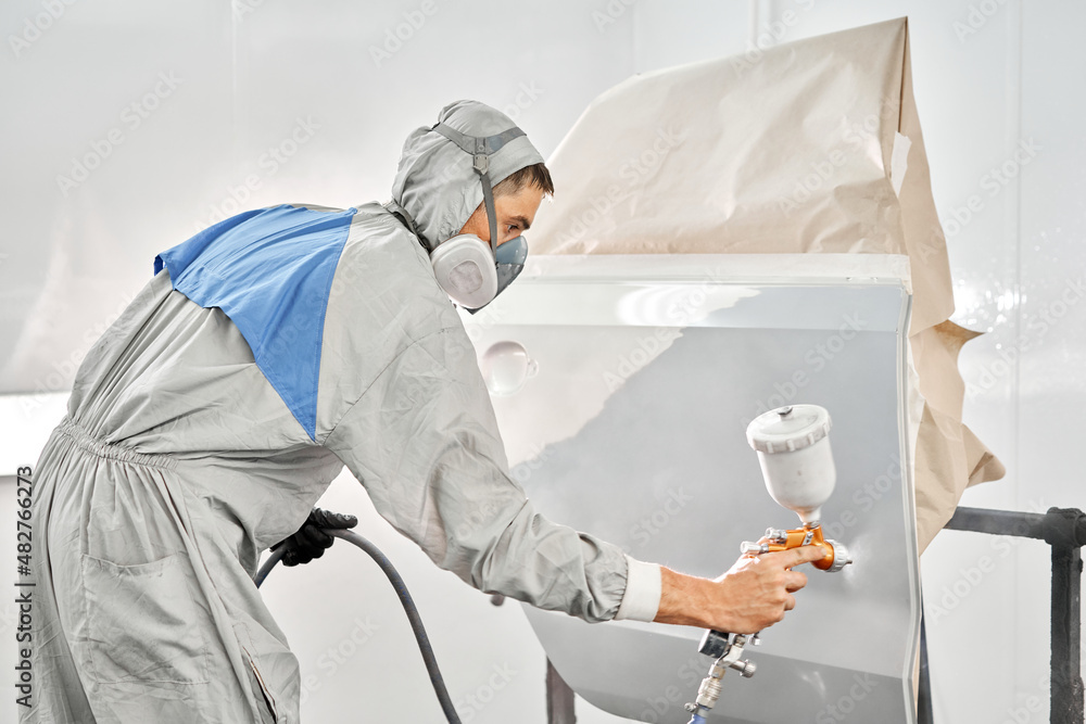 Painting the rear door of the car. Car painter in special painting ...