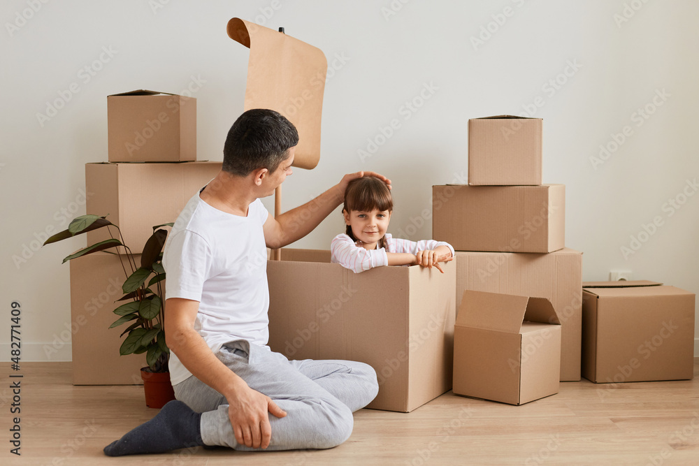 Little girl with her father making ship with flag during relocation and ...