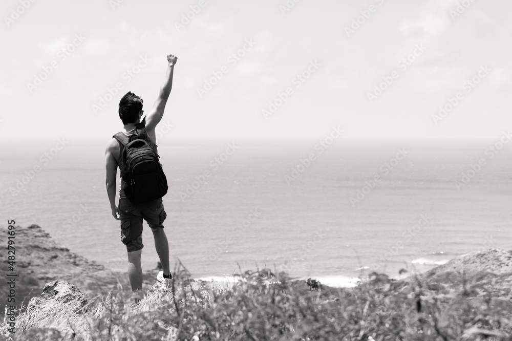 Strong determined man hiker on a mountain top with sifters up tot he ...