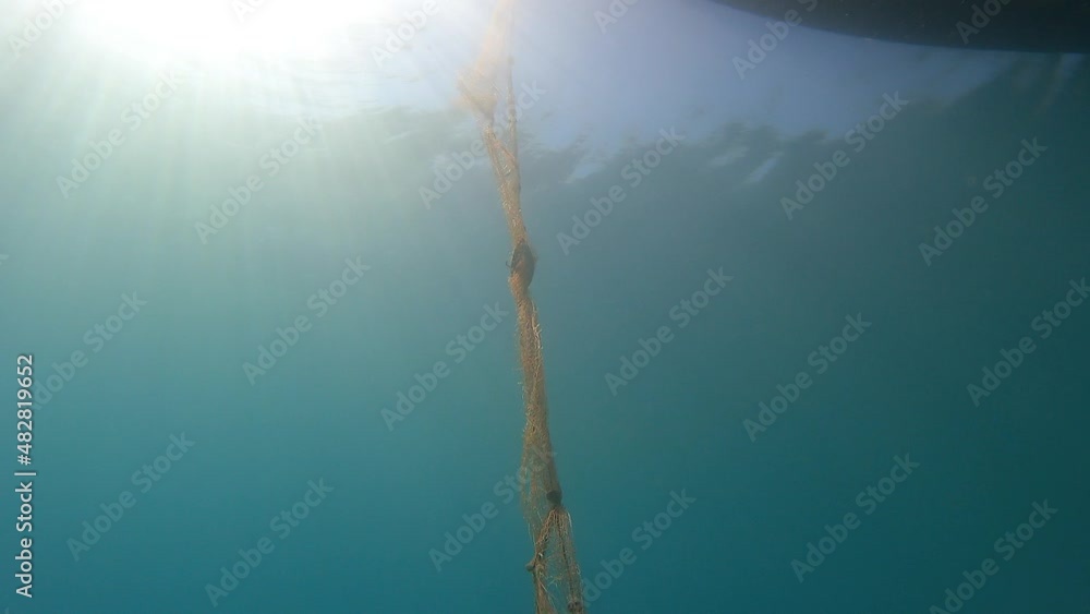 4K.Fishing net hanging from the boat under the sea.Underwater fishing ...