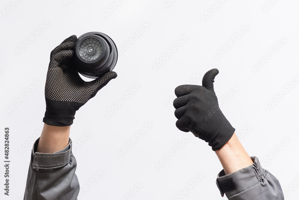 A cctv camera in the hand and thumbs up gesture isolated on the white ...