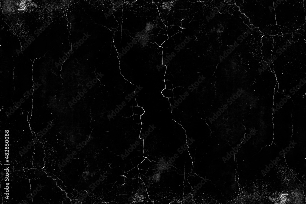 Cracked black concrete floor surface with scattered dust particles for ...