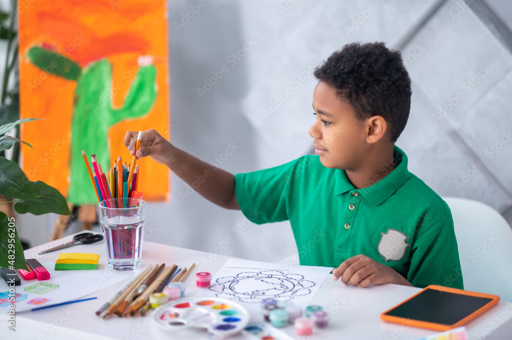 Profile of boy taking out pencil from glass Stock Photo | Adobe Stock