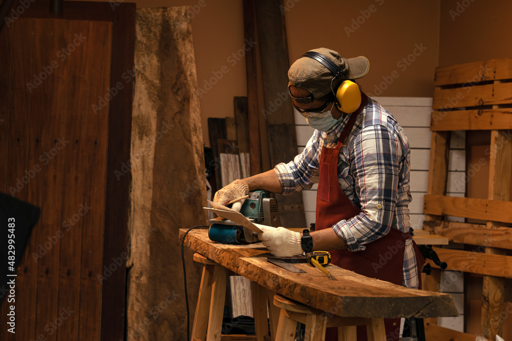 Carpenter with paper drawing while working in carpentry workshop ...