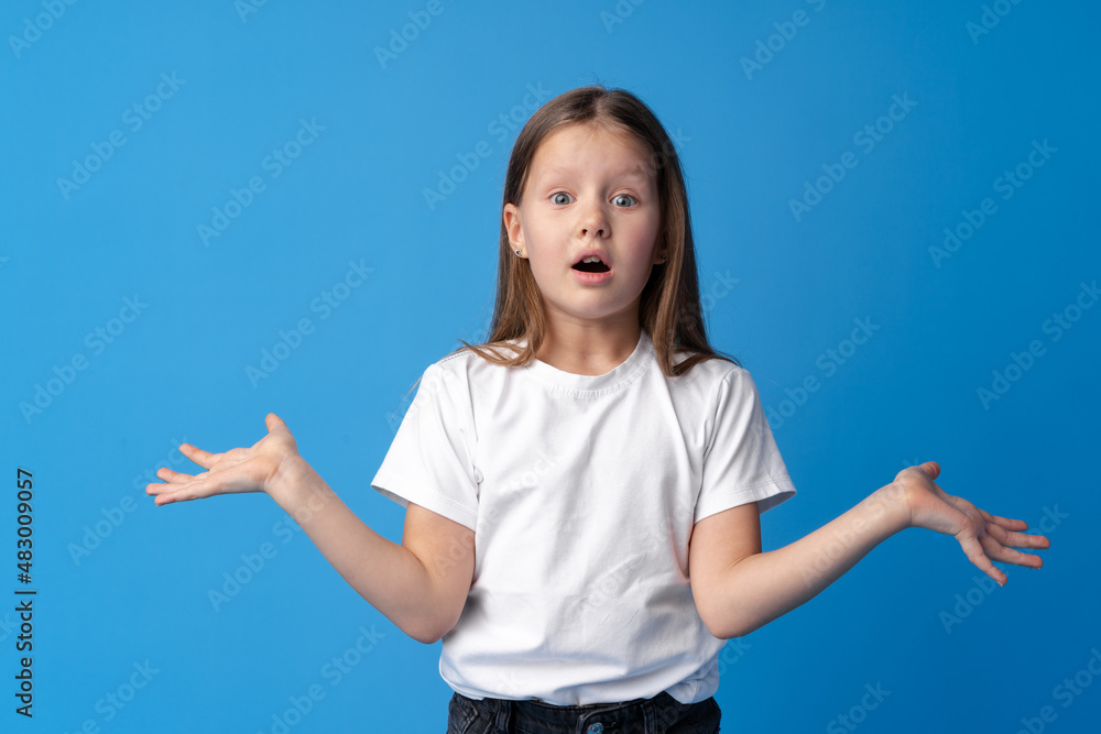 Shocked little girl looking with amazement on blue background Stock ...