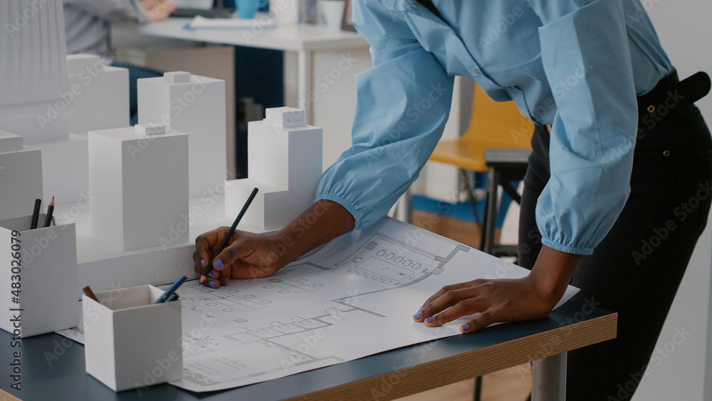Close up of woman looking at blueprints plans to work on architecture ...
