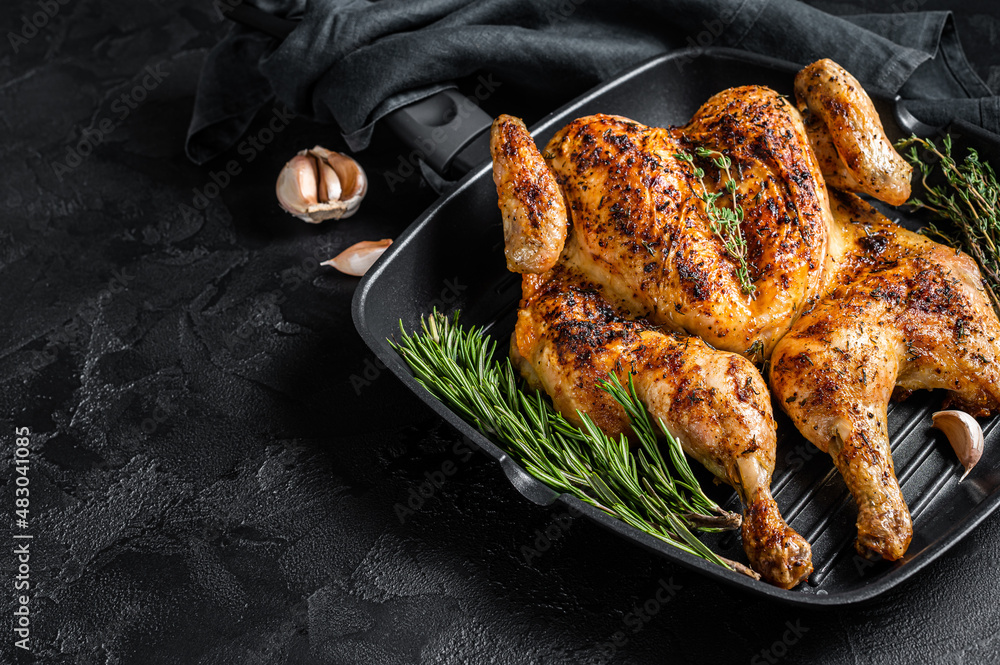 BBQ spatchcocked barbecue whole chicken on grill pan. Black background ...
