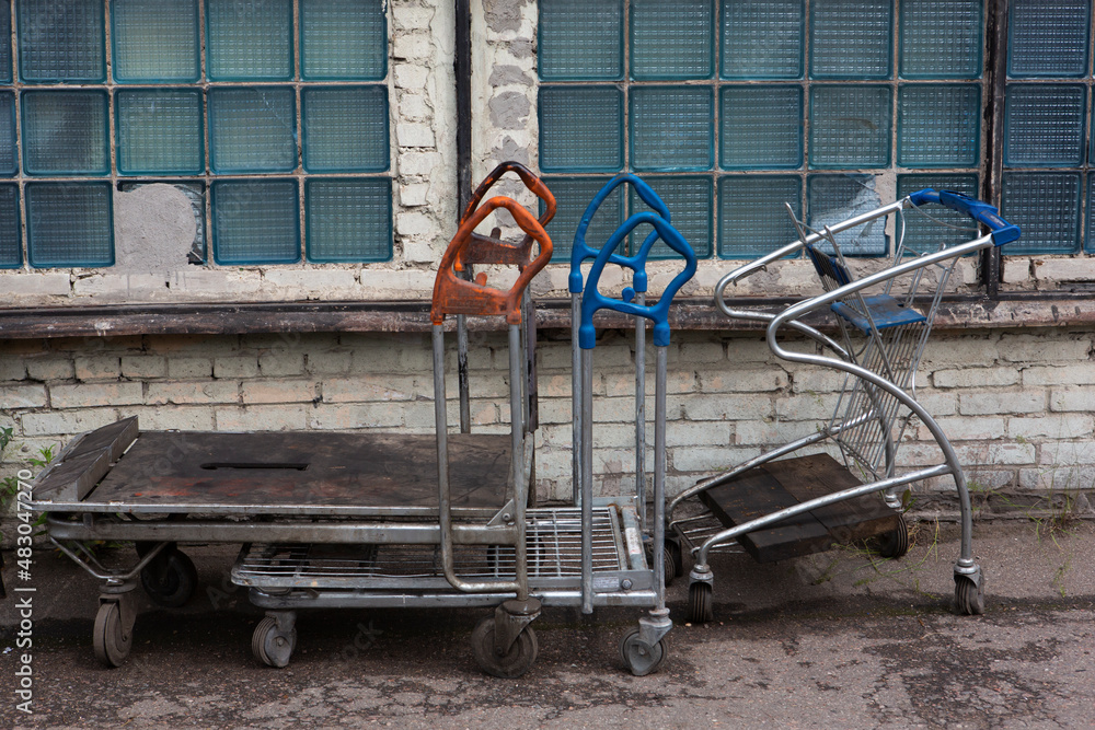 piled dirty rusty weathered cargo trolleys and standing outside on a ...