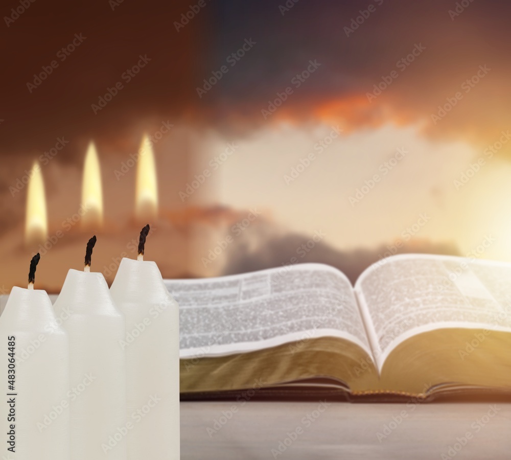 Candles and an open book as a symbol of religion. holy book and morning ...