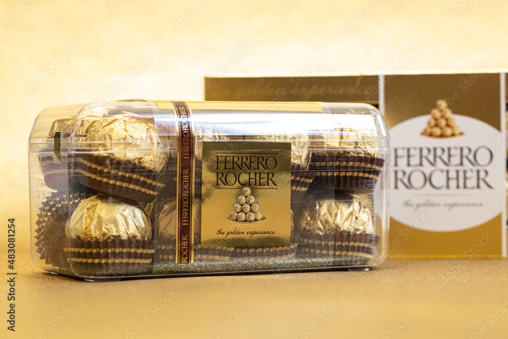 isolated Ferrero Rocher premium chocolate on golden glitter background ...