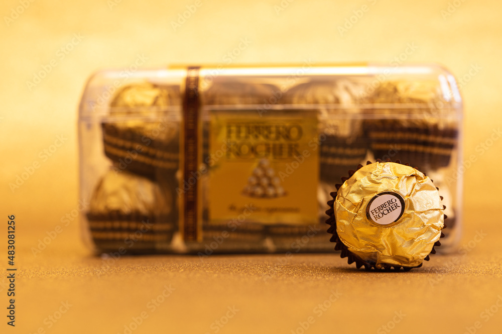 isolated Ferrero Rocher premium chocolate on golden glitter background ...