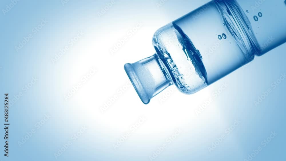 Drop of hypochlorous acid drips into old fashioned bottle with blue ...
