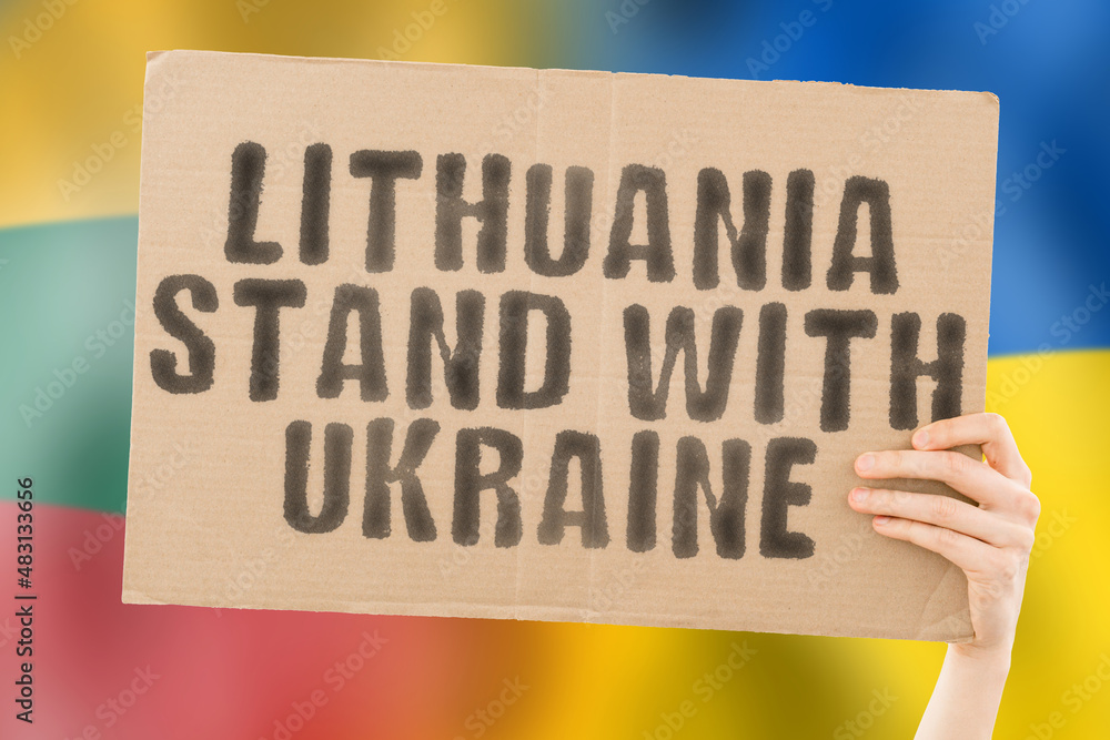 The phrase " Lithuania stand with Ukraine " on a banner in men's hand ...