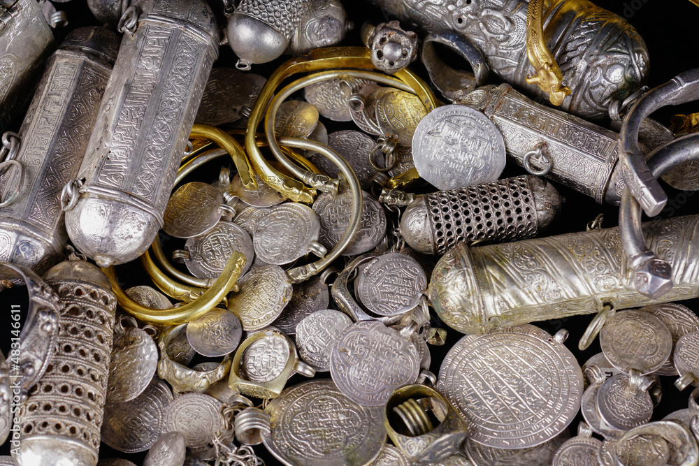 A lot of stacked gold bullion bars and gold coins and silver coins in a ...