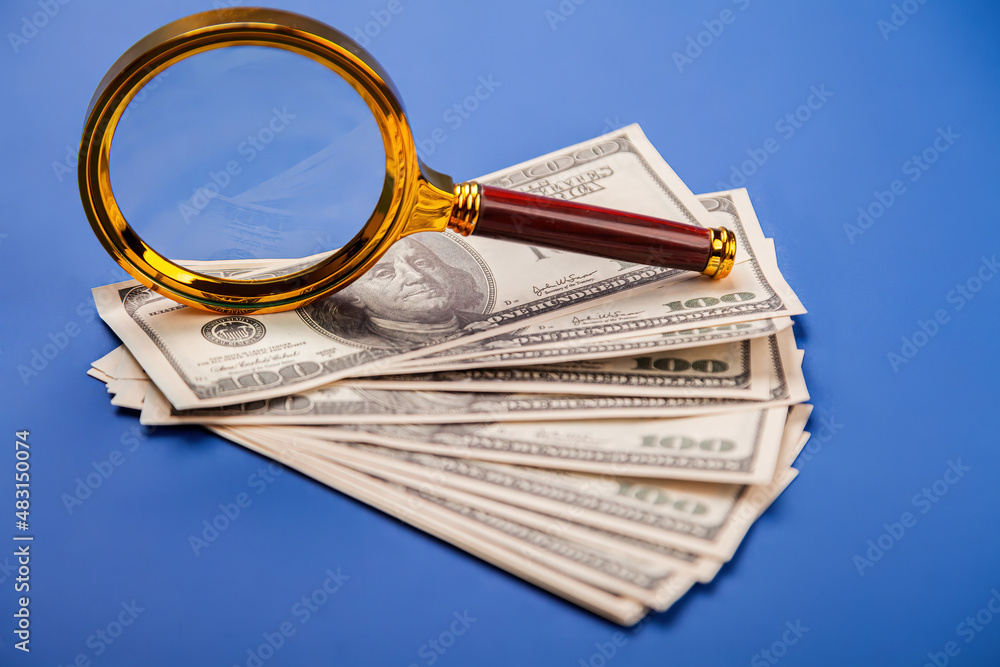 Money with a magnifying glass. Finding profits and losses. A business ...